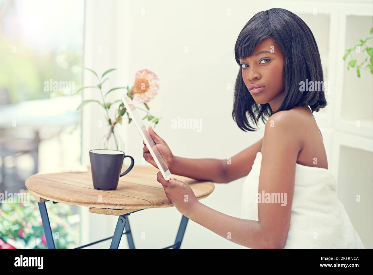 Its all part of my morning routine. A young woman working on her tablet ...