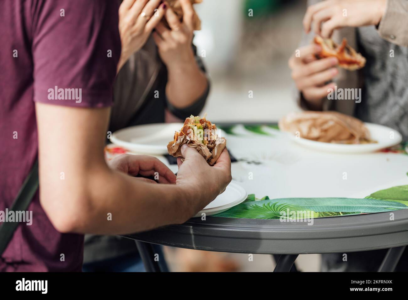A man eating burger at the festival food court Stock Photo - Alamy