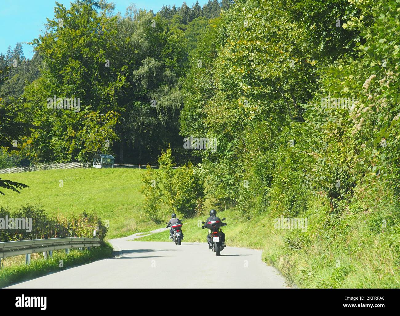 A beautiful view of two motorcycles driving on a road surrounded by ...