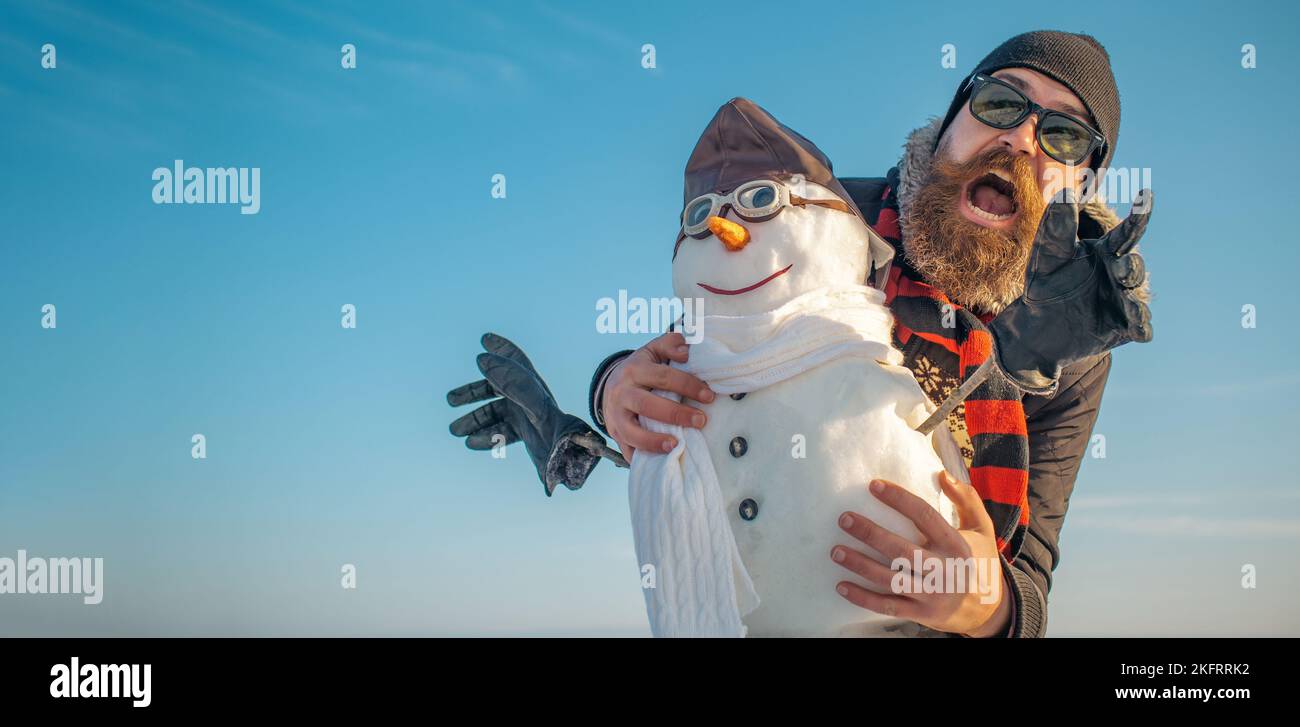 Excited man with snowman on winter outdoor background. Snow man for ...