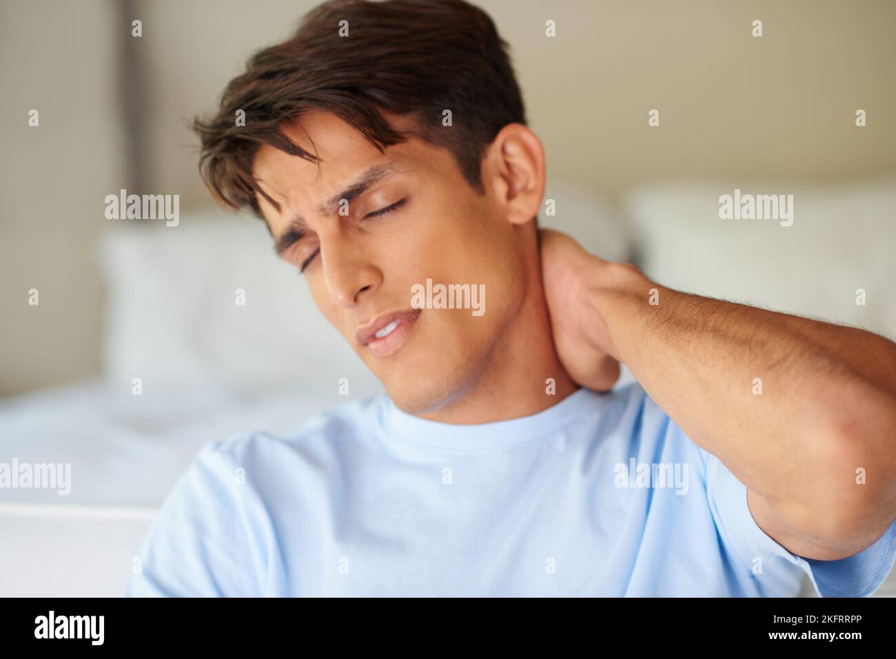 That hurts so bad. a handsome young man suffering from severe neck pain ...