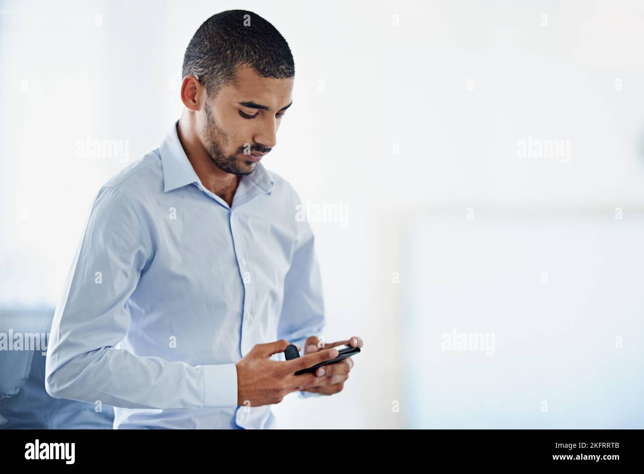 Always reachable. a young businessman sending a text message while ...