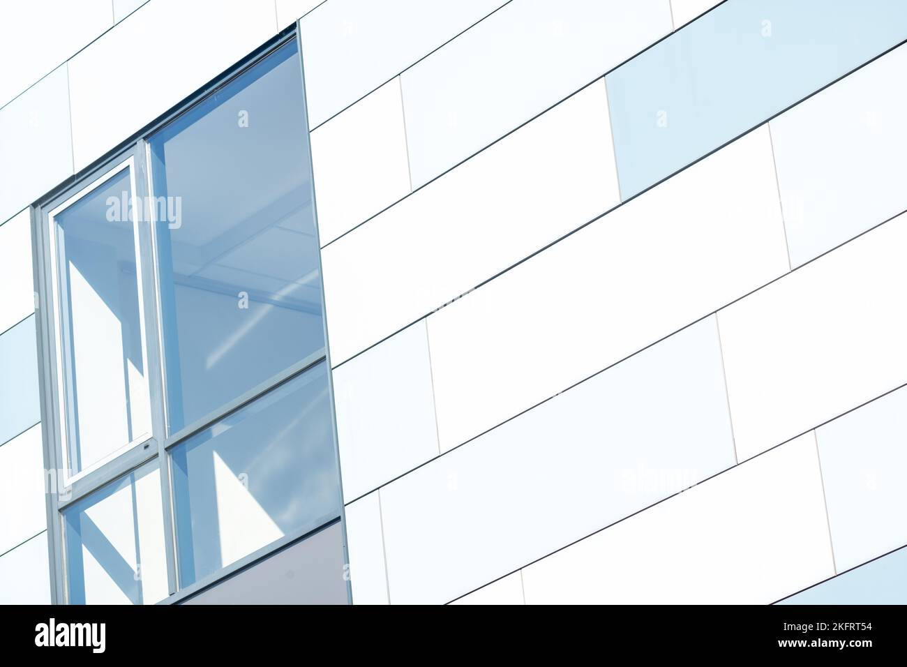 An exterior view of a modern building with blue tiled walls and glass ...