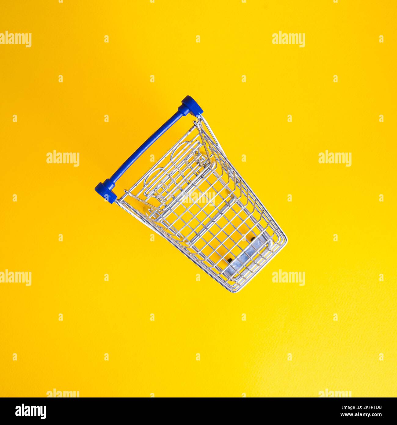 empty shopping cart over colour background, mini metal cart isolated on ...