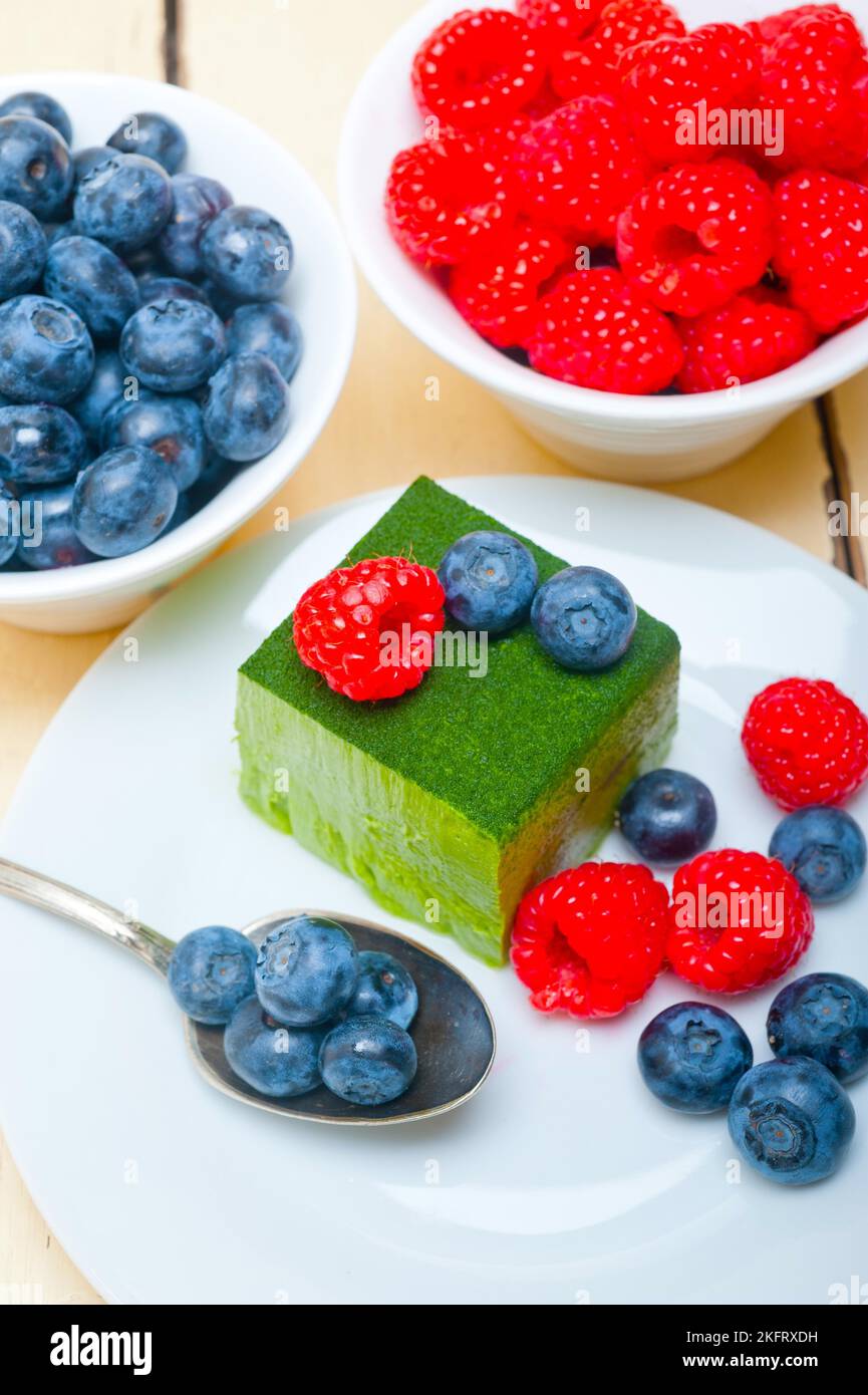 Green tea matcha mousse cake with raspberries and blueberries on top ...