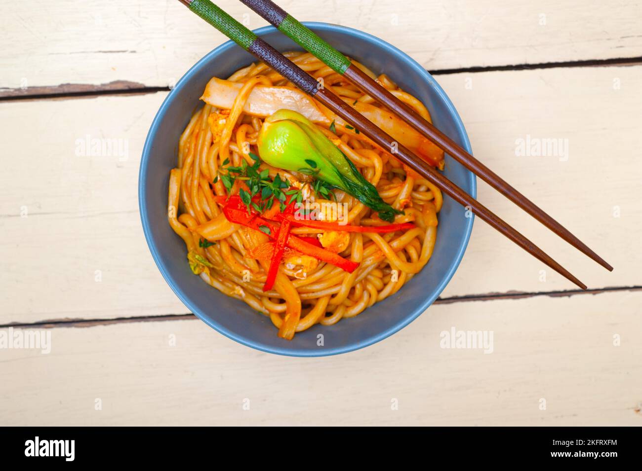 Hand pulled stretched Chinese ramen noodles on a bowl with chopstick ...
