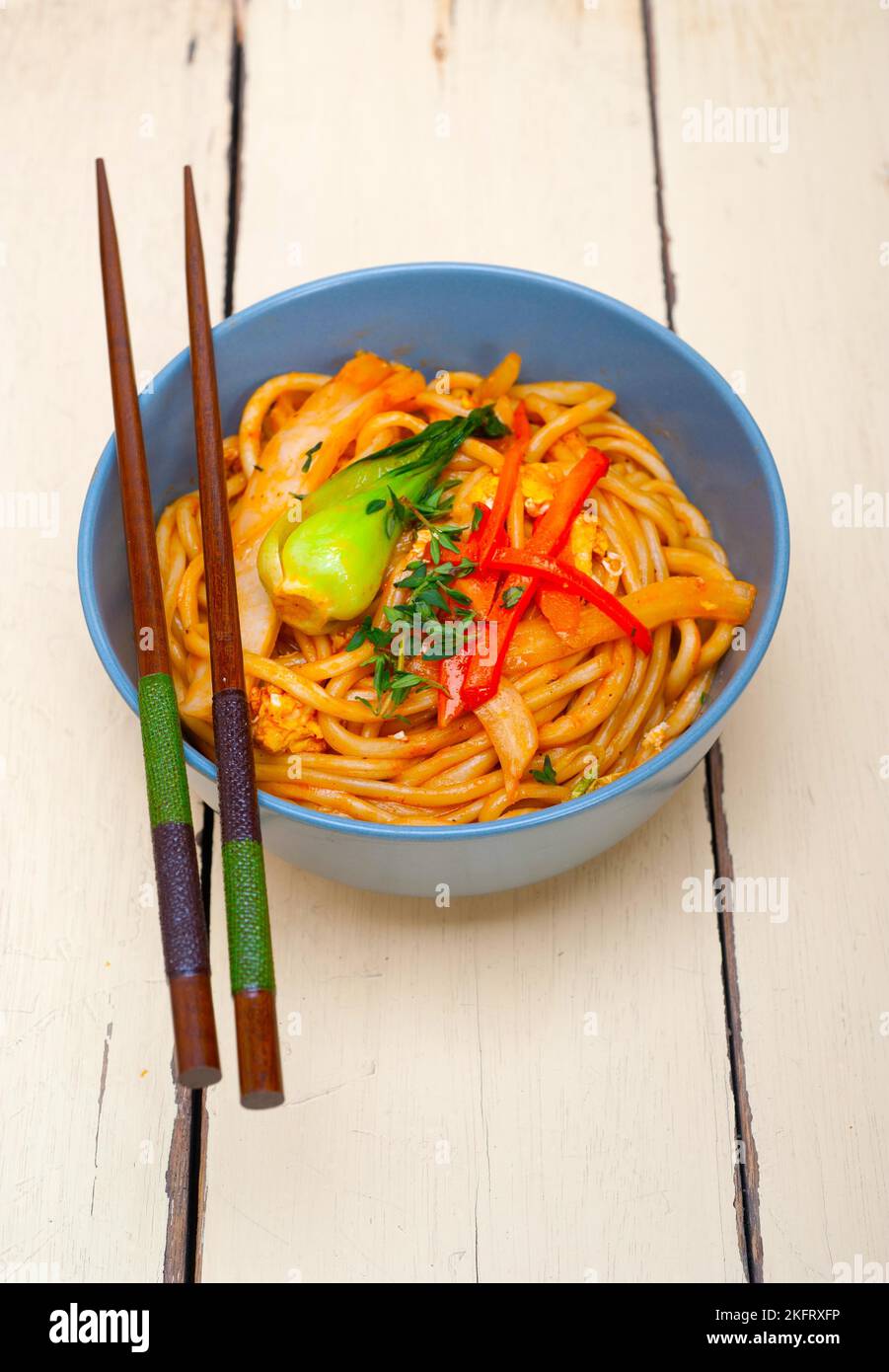 Hand pulled stretched Chinese ramen noodles on a bowl with chopstick ...