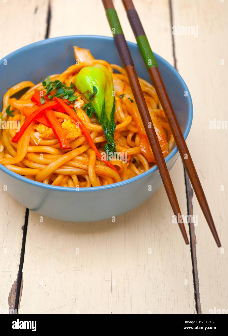 Hand pulled stretched Chinese ramen noodles on a bowl with chopstick ...