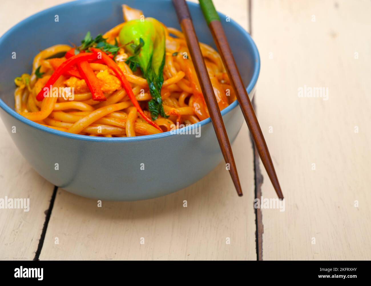 Hand pulled stretched Chinese ramen noodles on a bowl with chopstick ...