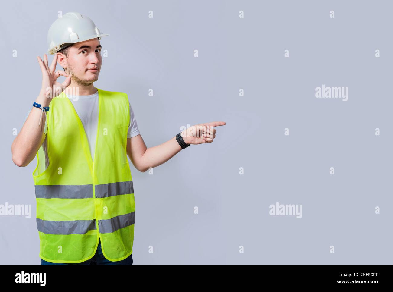 Handsome engineer recommending a product on white background, Young ...