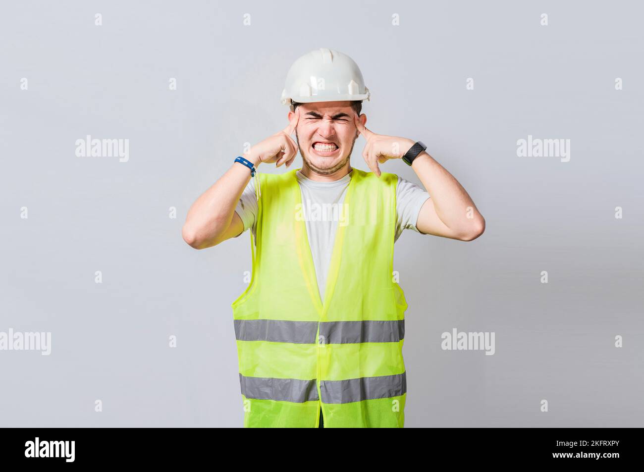 Young engineer covering his ears isolated, Builder man with ear pain ... Young engineer covering his ears isolated, Builder man with ear pain ...