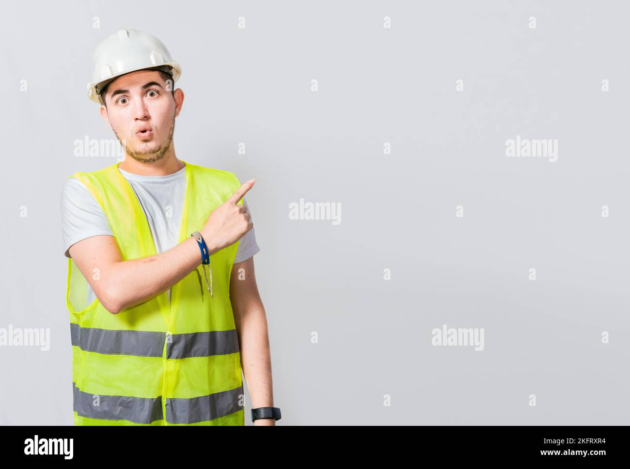 Surprised face construction worker pointing at an advertisement ...