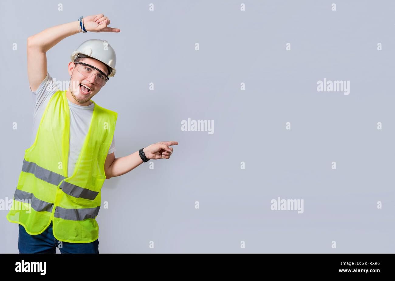Construction engineer with vest pointing at an advertisement. Engineer ...