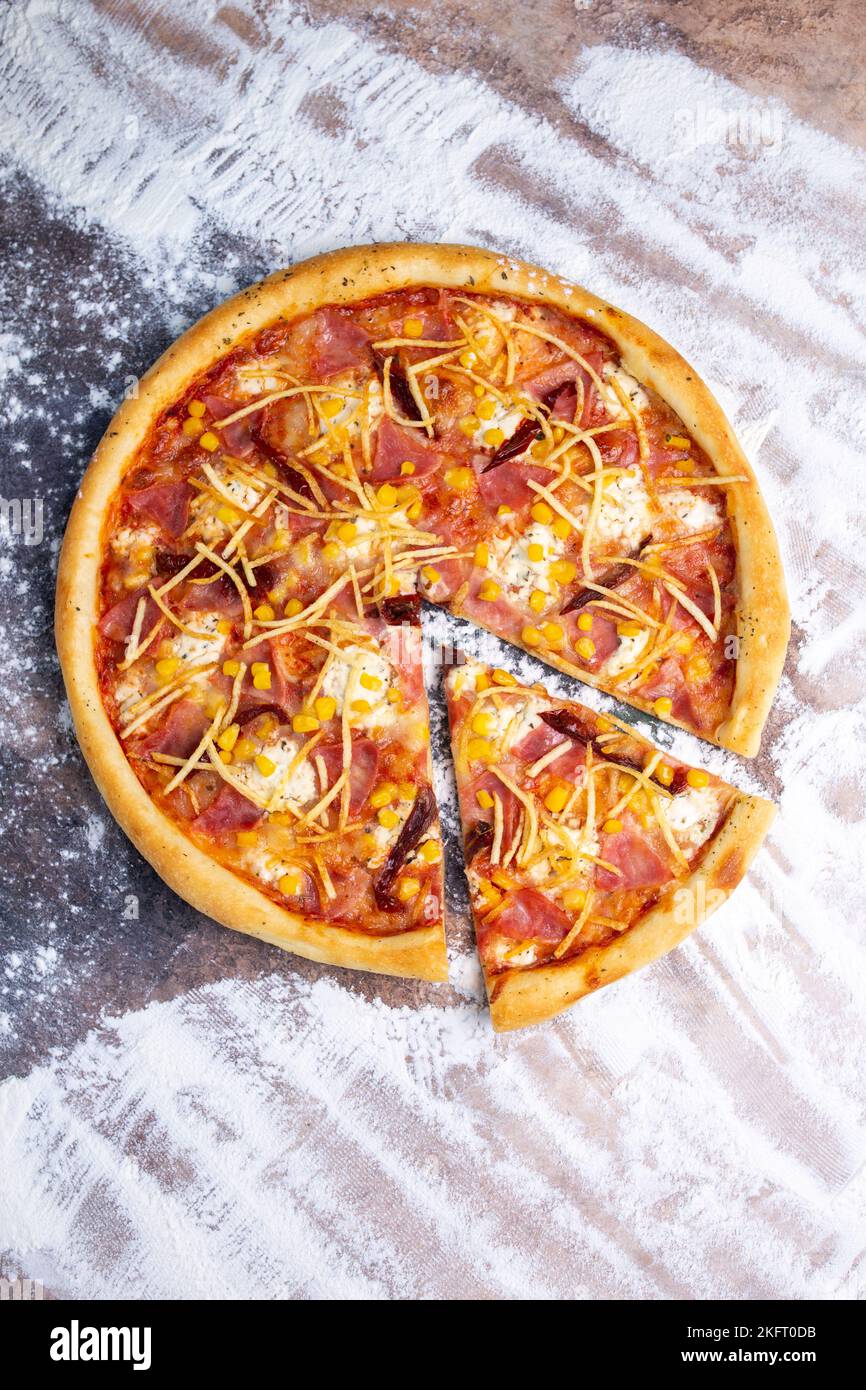 top view pizza with ham and corn on the background of flour Stock Photo ...