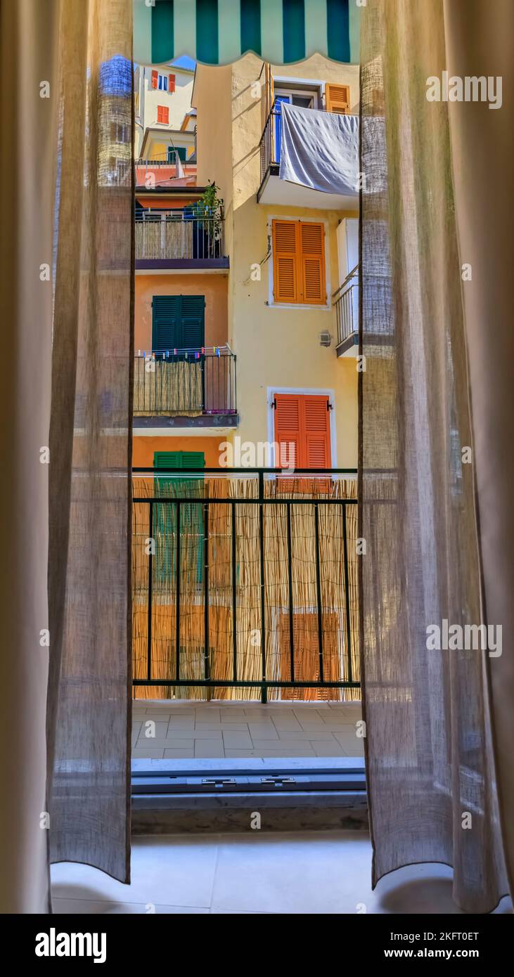 View through an open window onto traditional colorful houses on a ...