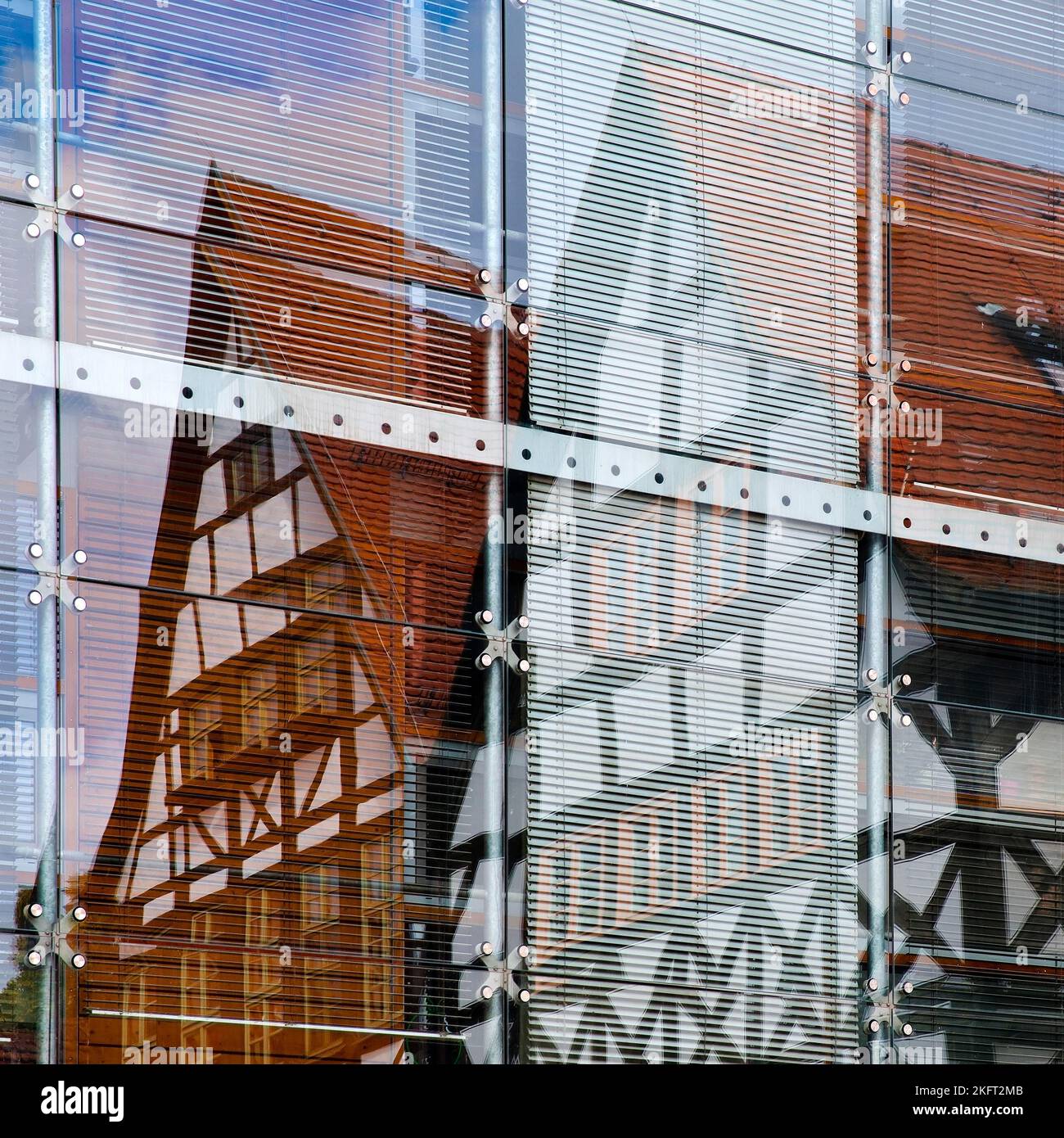Reflection of half-timbered houses in a modern glass façade in the old ...
