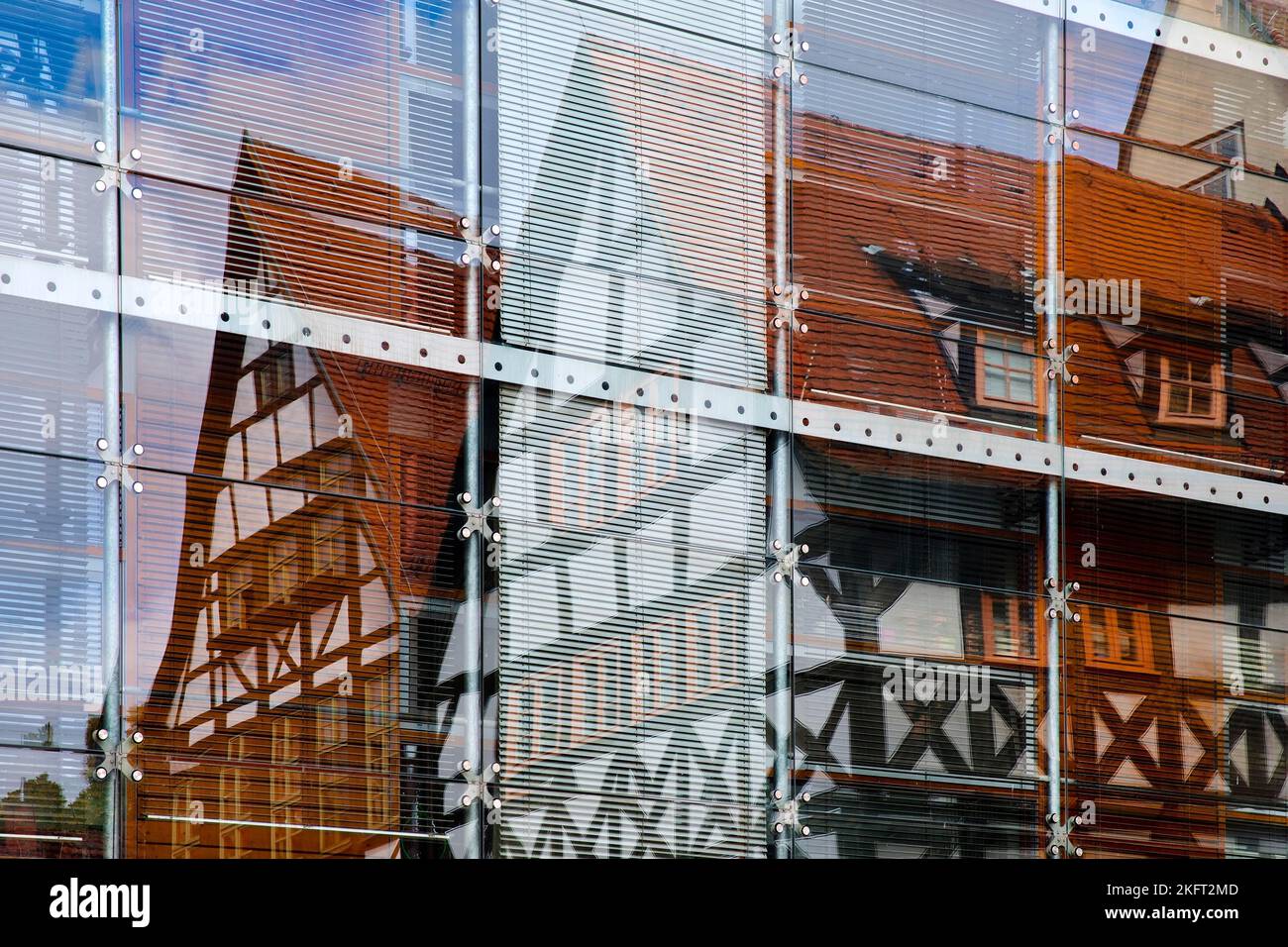 Reflection of half-timbered houses in a modern glass façade in the old ...
