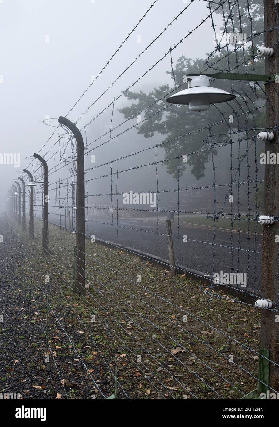 Reconstructed camp fence with crematorium in the fog at beech forest ...