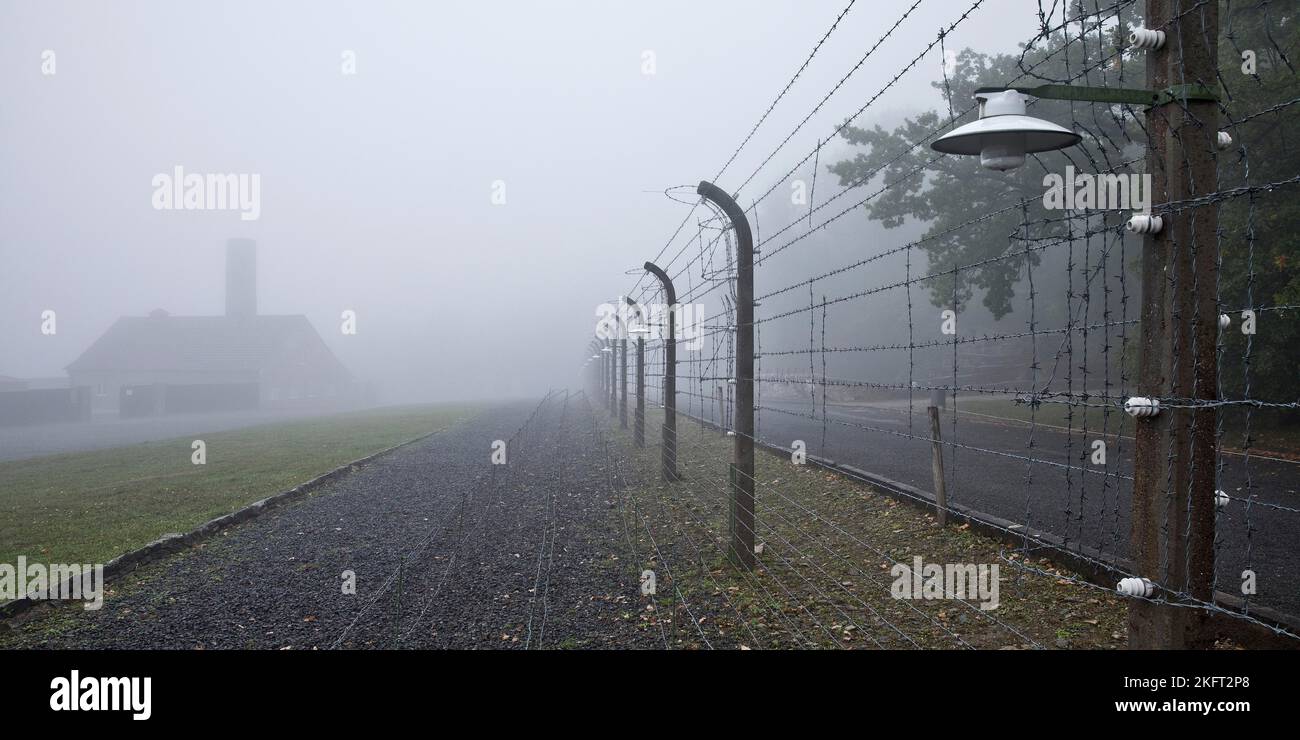 Reconstructed camp fence with crematorium in the fog at beech forest ...