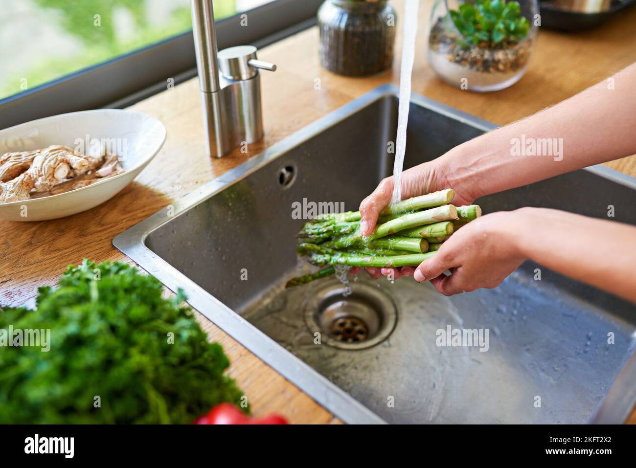 Only use the freshest ingredients. a woman washing vegetables in a ...
