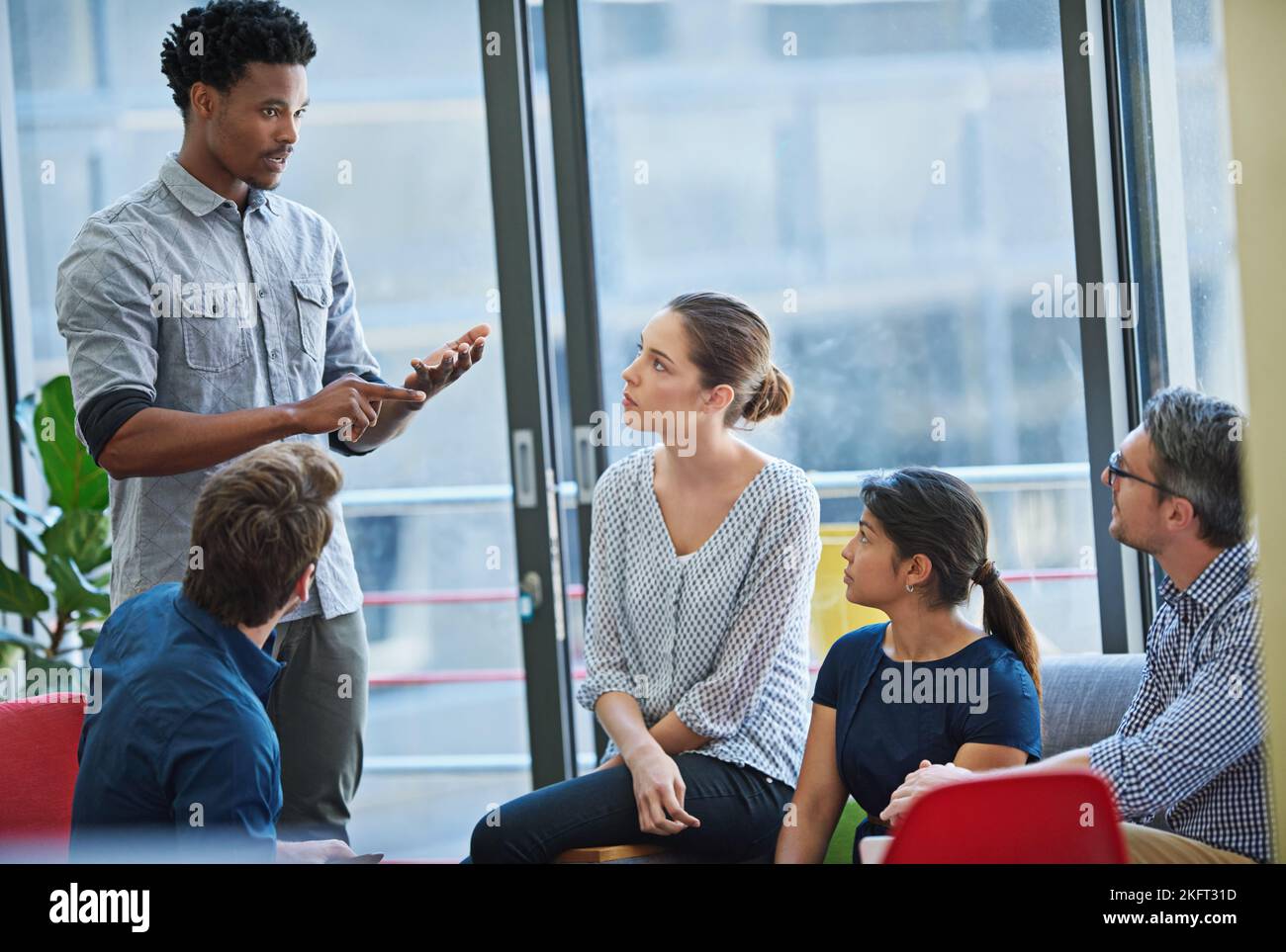 The go to idea guy. a group of office workers talking together in a ...