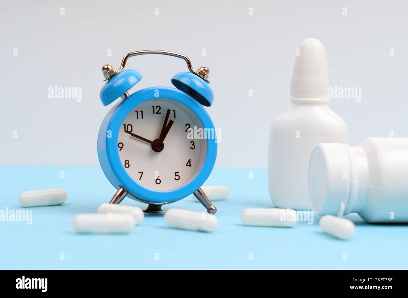 Medical concept. On a blue and white background, a blue clock, white ...