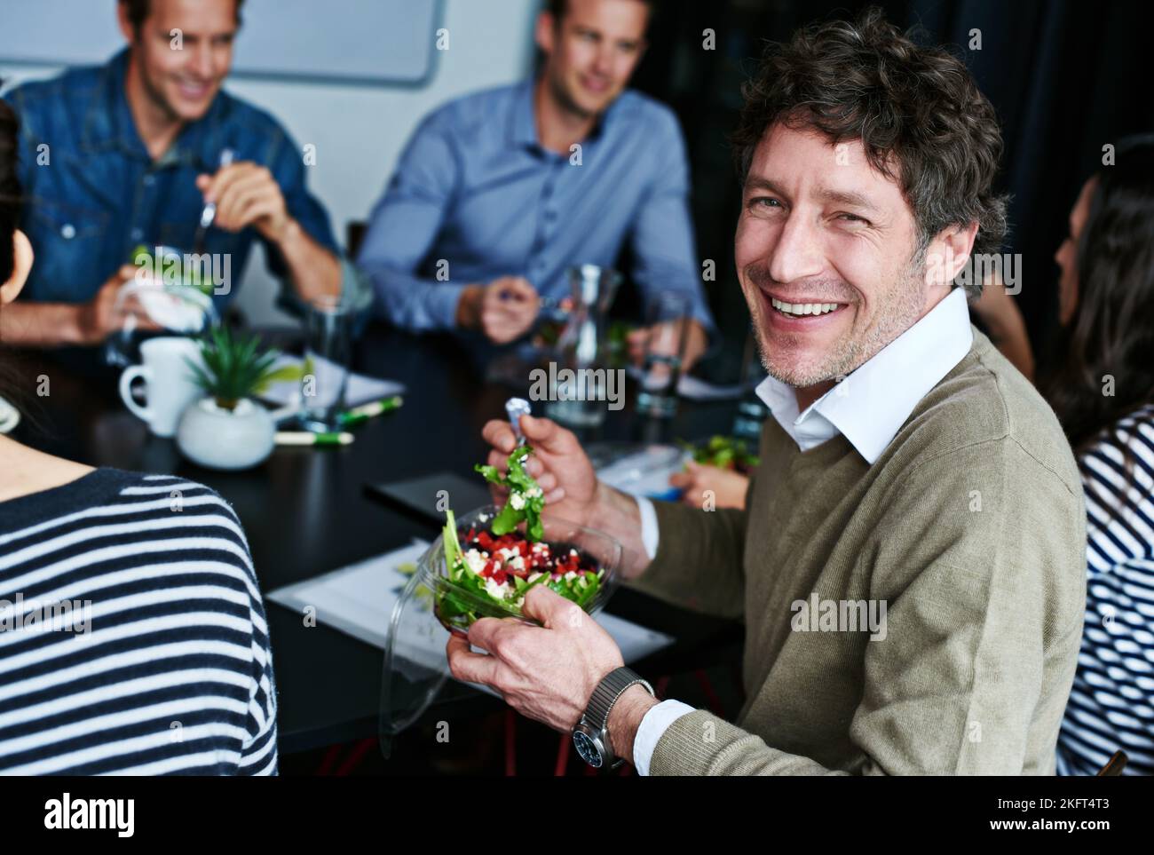 Enjoying lunch with colleagues and friends. Portrait of an office ...