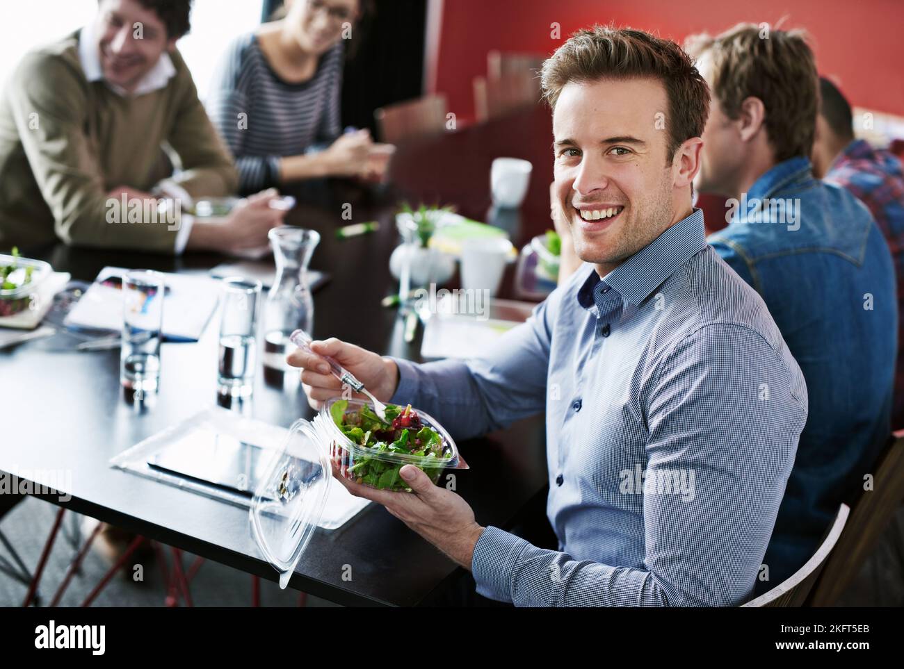 Enjoying a healthy meal in the boardroom. Portrait of a young office ...