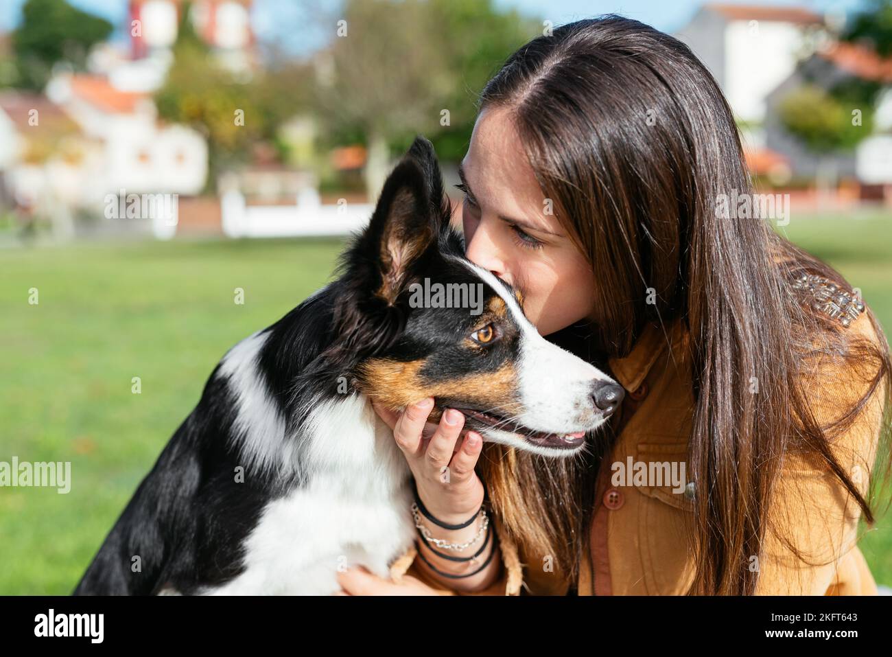 Young woman in casual clothes kissing adorable Border Collie looking ...