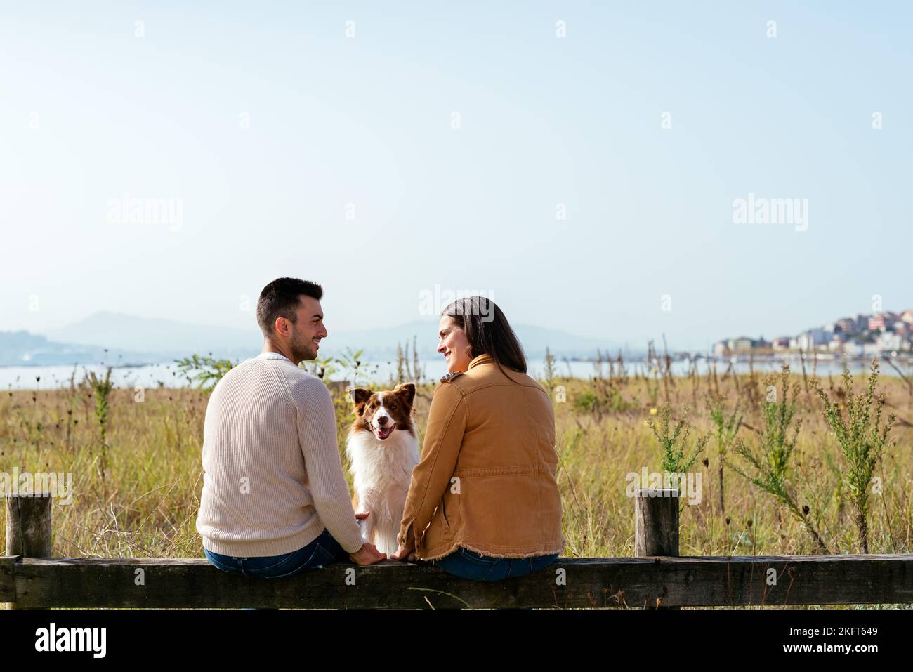 Back view of loving couple in casual clothes looking at each other ...