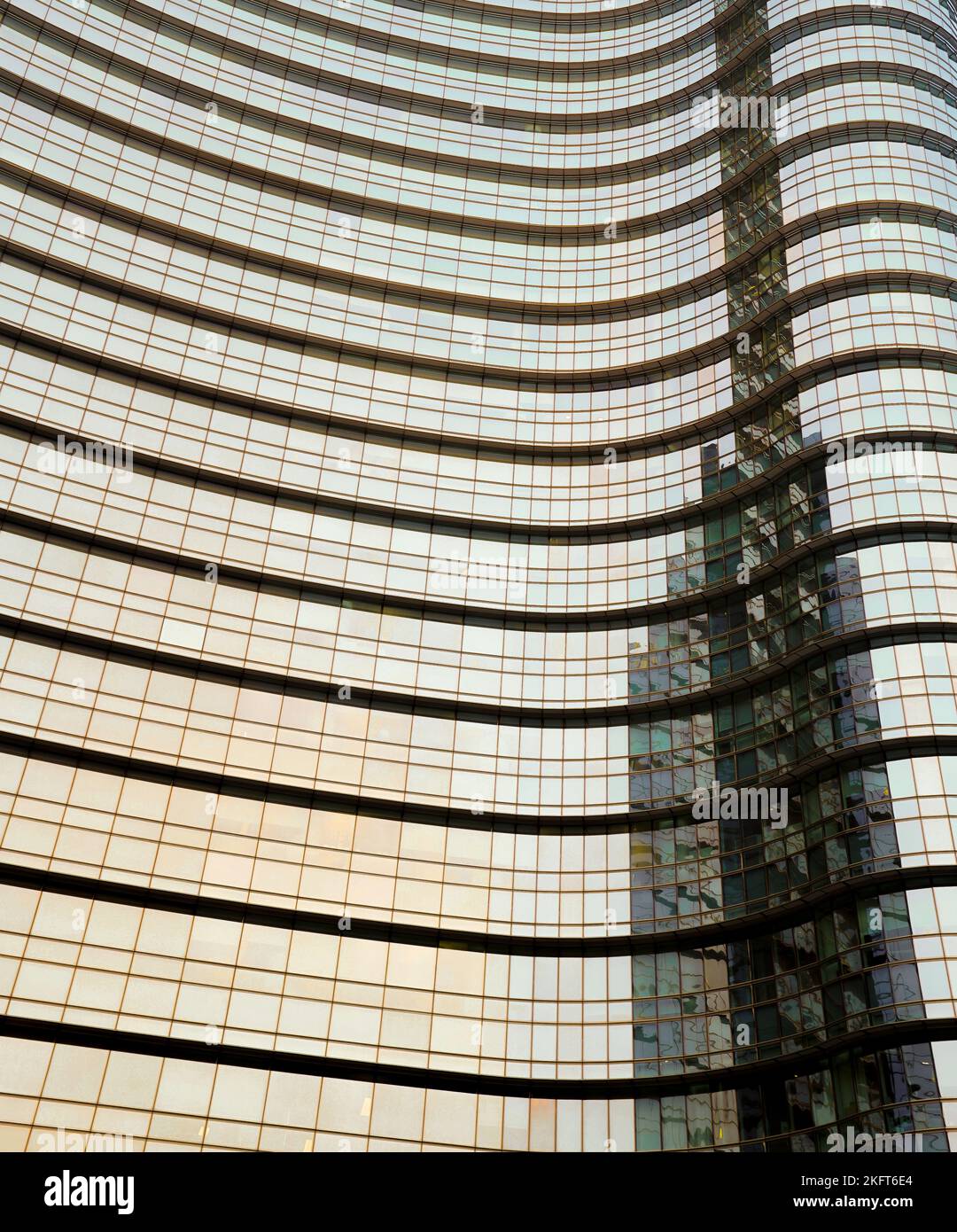 From below curvy modern high glass rise building with spire on city ...