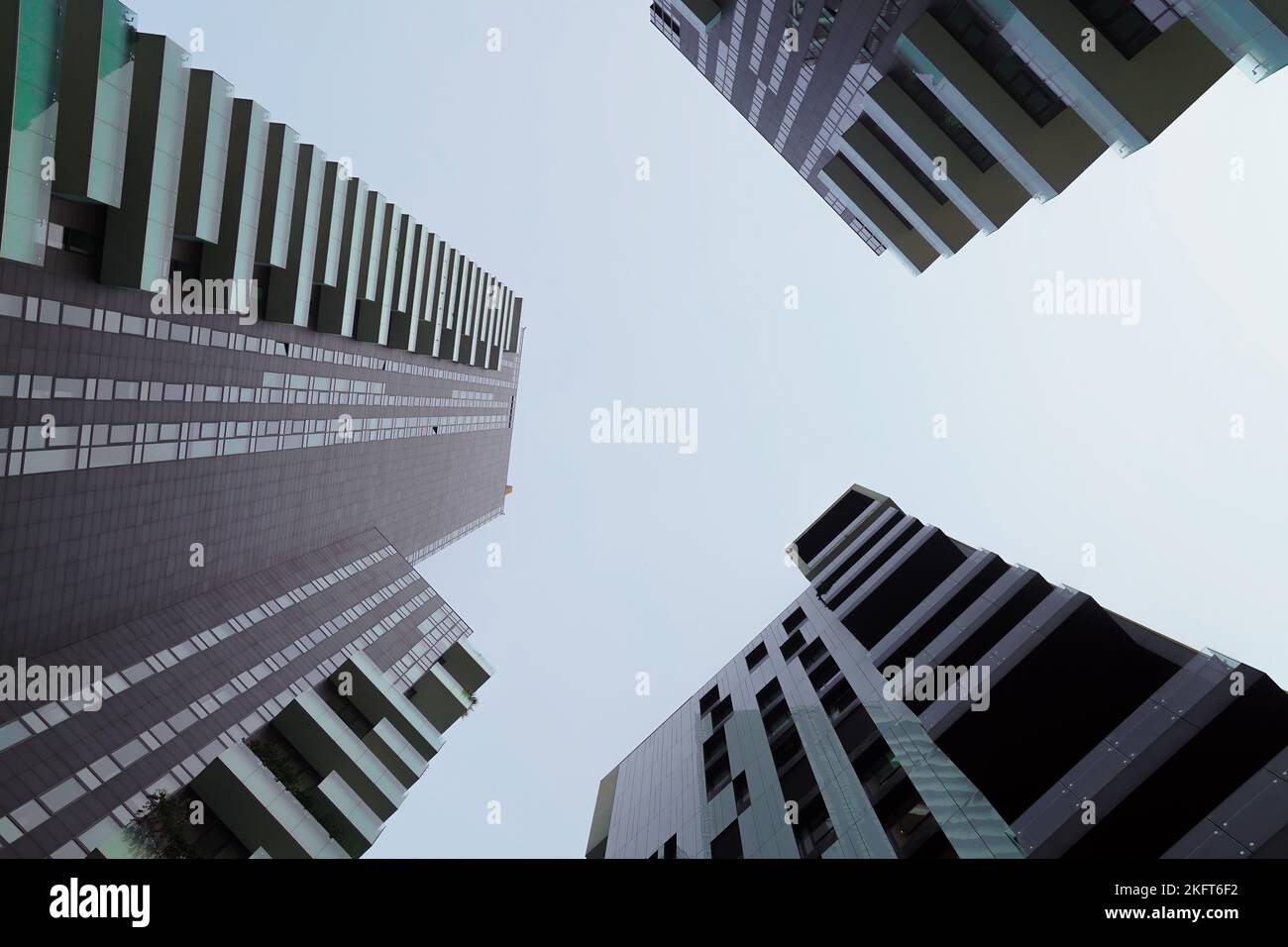 Low angle of futuristic glass skyscrapers located against dull sky on ...