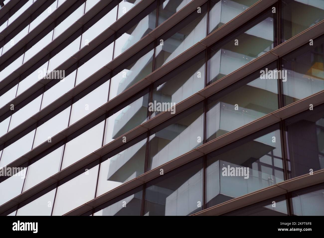 From below curvy modern high glass rise building with spire on city ...