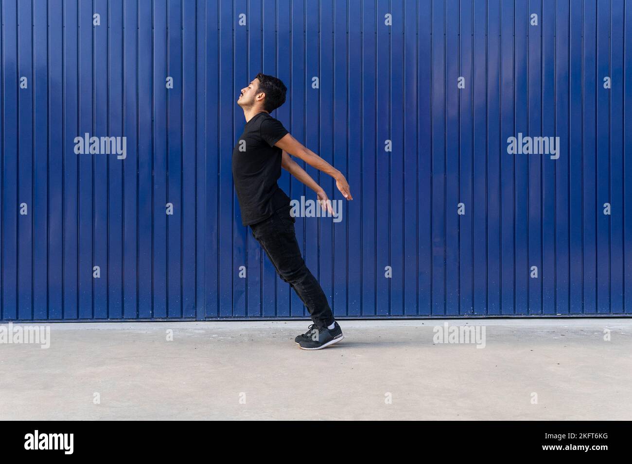 Side view full body of active male dancer jumping on street against ...