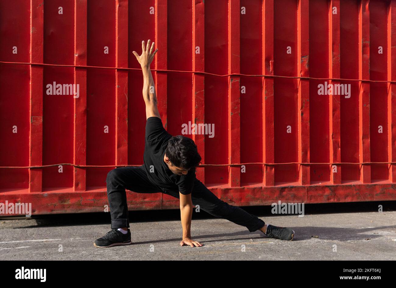Full body of male dancer practicing movement while standing with one ...