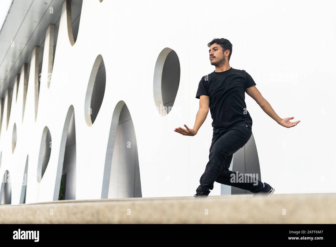 From below full body of male dancer in black casual outfit performing ...