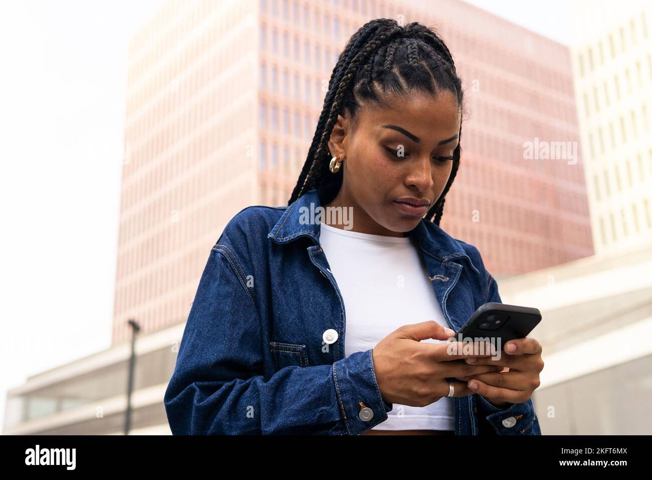 Low angle of African American female browsing mobile phone messaging on ...