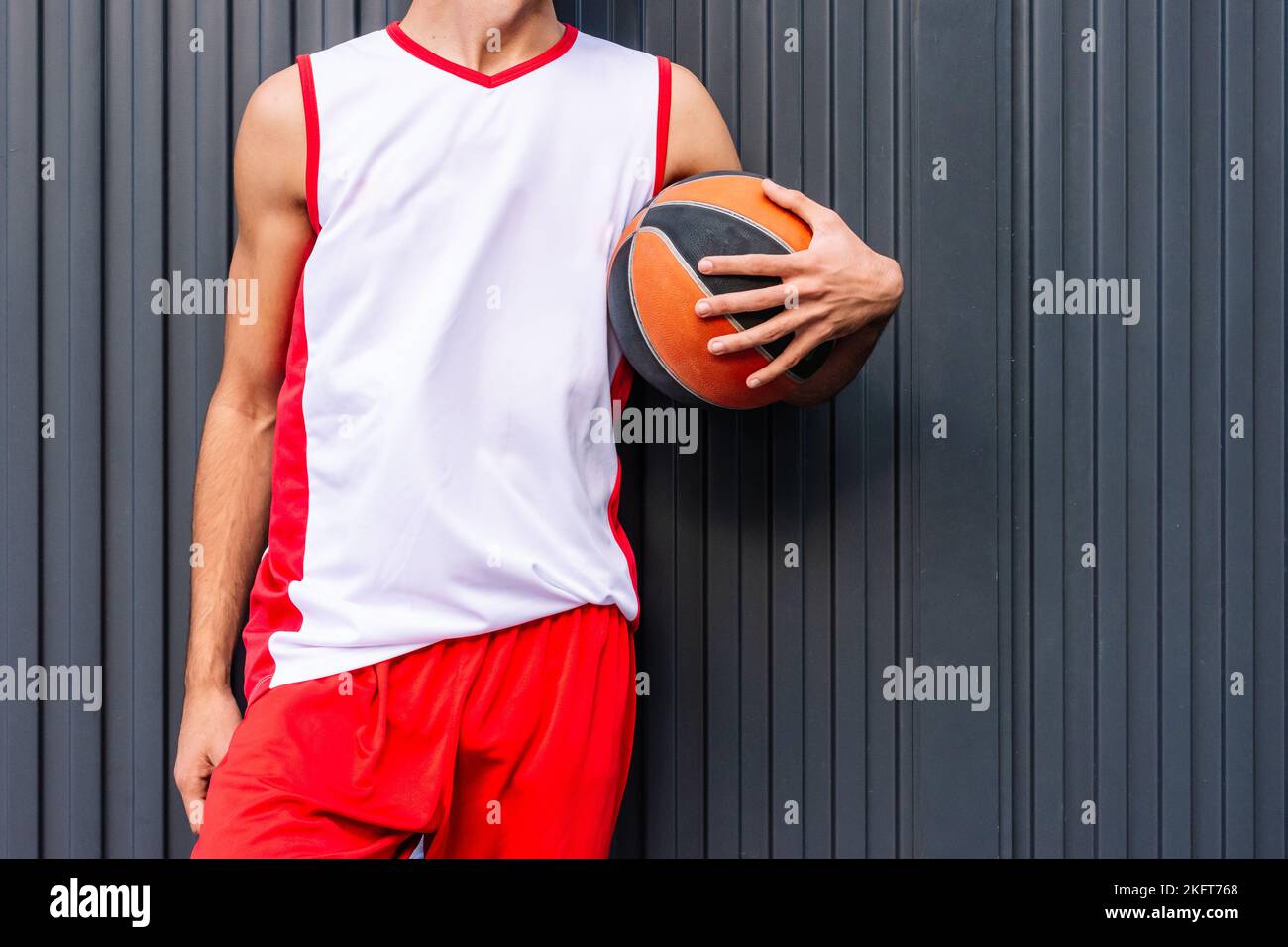 Crop view of anonymous man in activewear with ball standing against ...