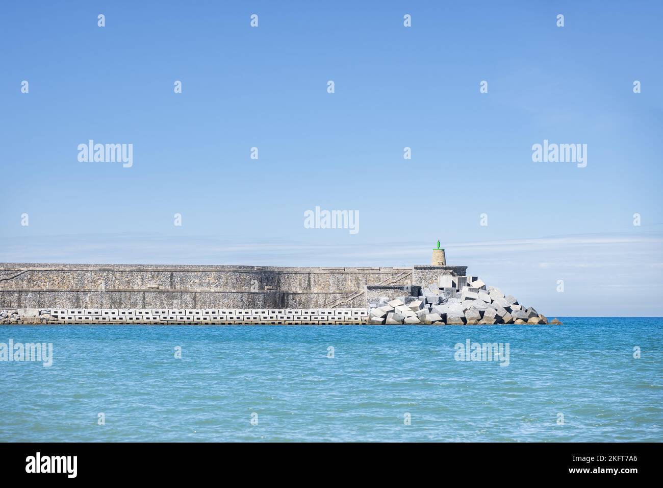 Scenic view of lighthouse located on shore of rippling sea against blue ...