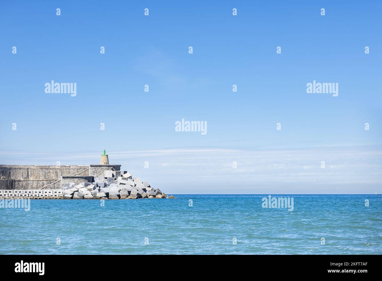 Scenic view of lighthouse located on shore of rippling sea against blue ...