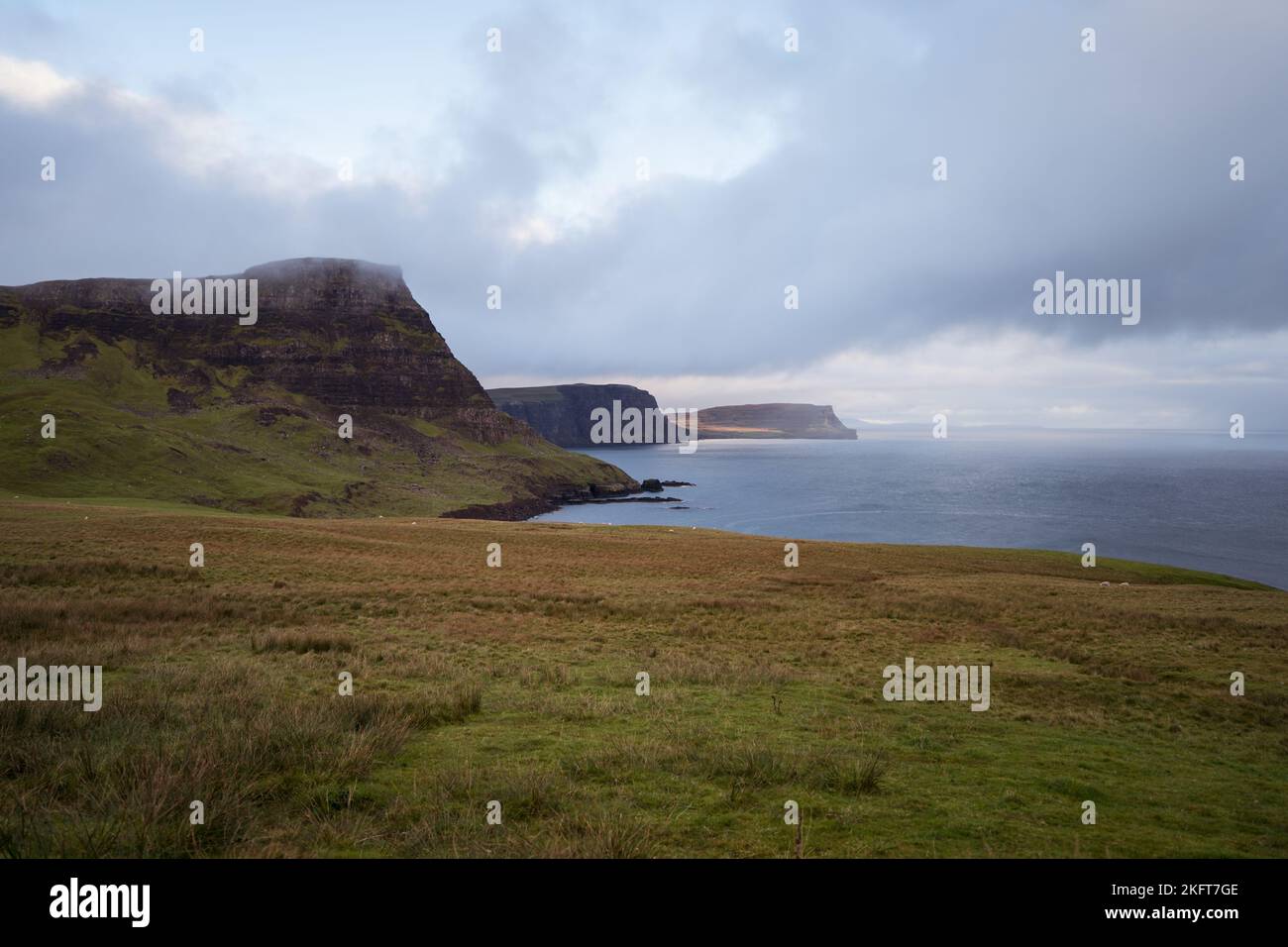 Spectacular scenery of calm sea surrounded by hills in overcast weather ...