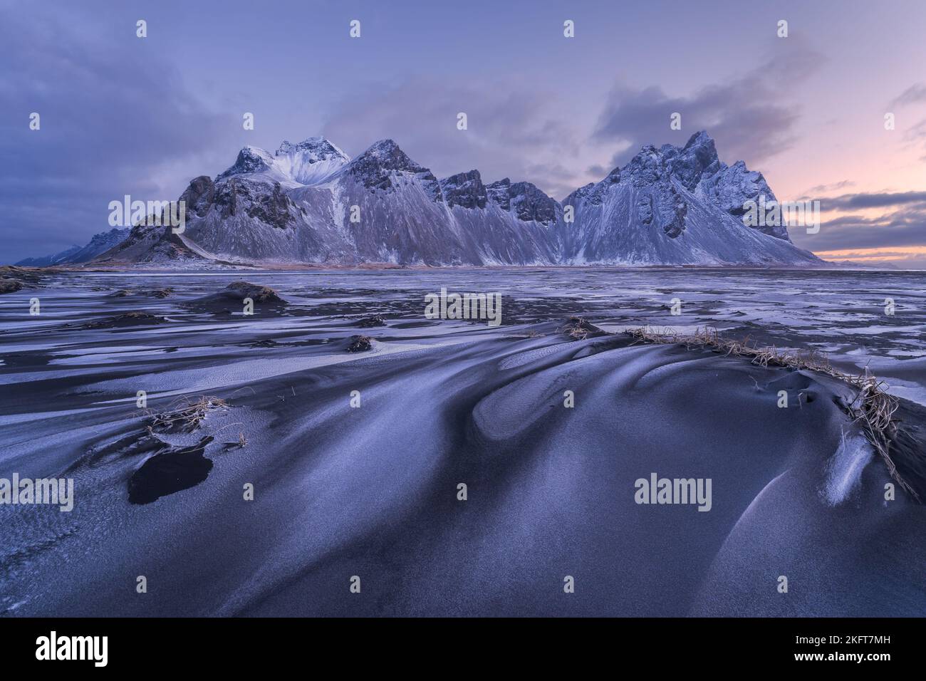 Calm frozen endless sea surrounding with black frozen sand and high ...