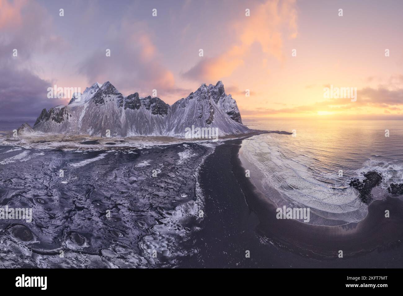 Calm frozen endless sea surrounding with black frozen sand and high ...
