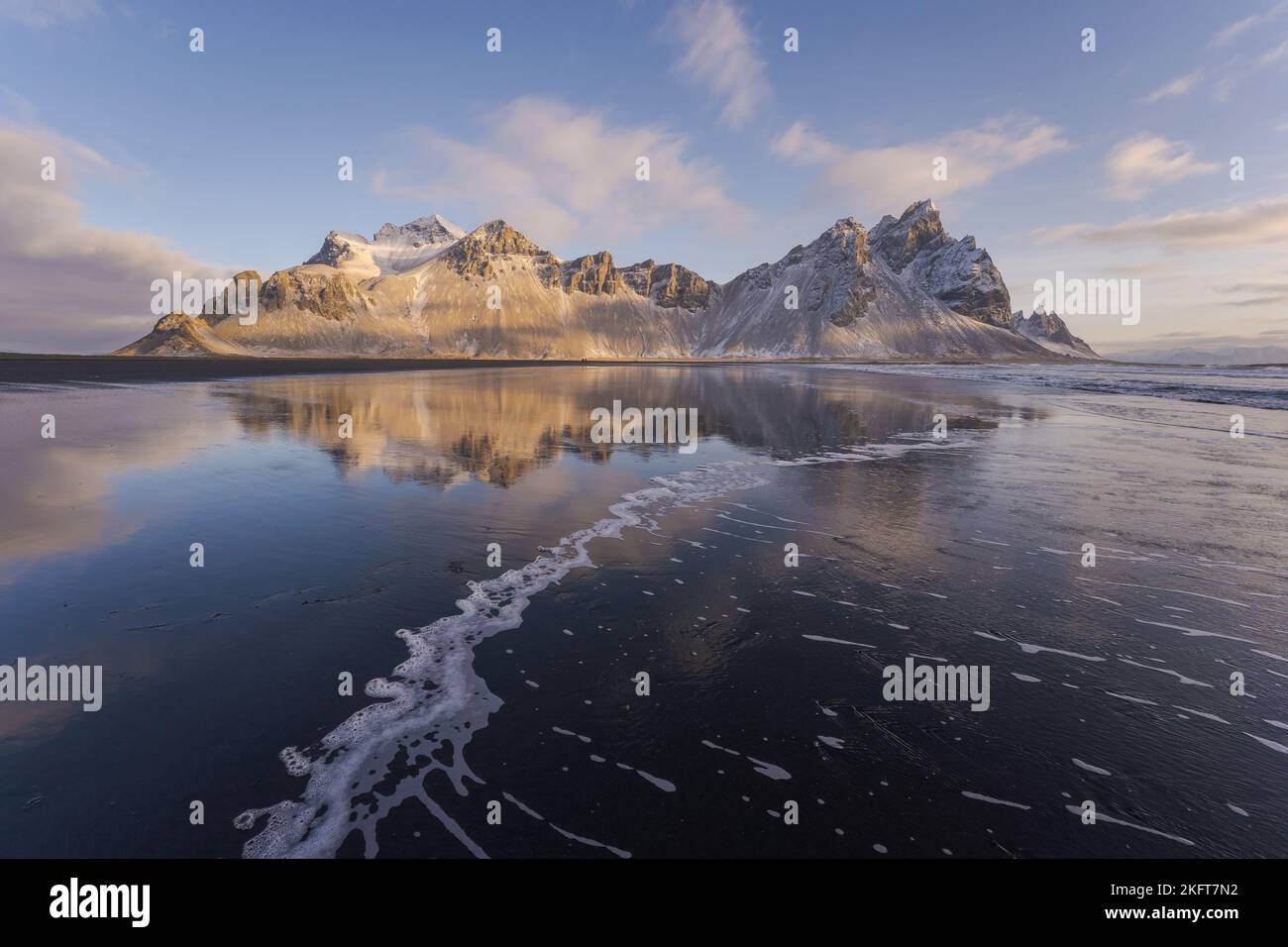 Calm frozen endless sea surrounding with black frozen sand and high ...