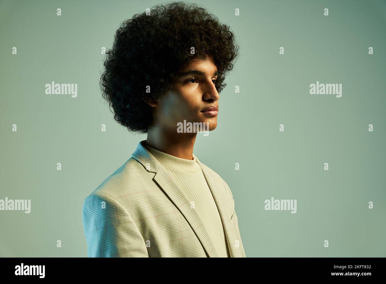 Side view young Hispanic male model in stylish suit with curly hair ...