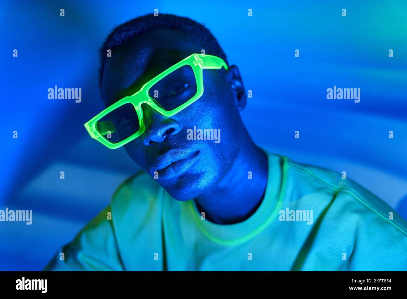 Confident African American male in neon trendy sunglasses and green t ...