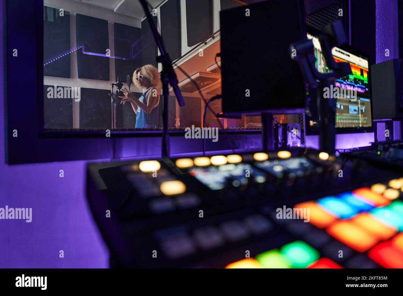View through window of professional musician with Afro hair recording ...