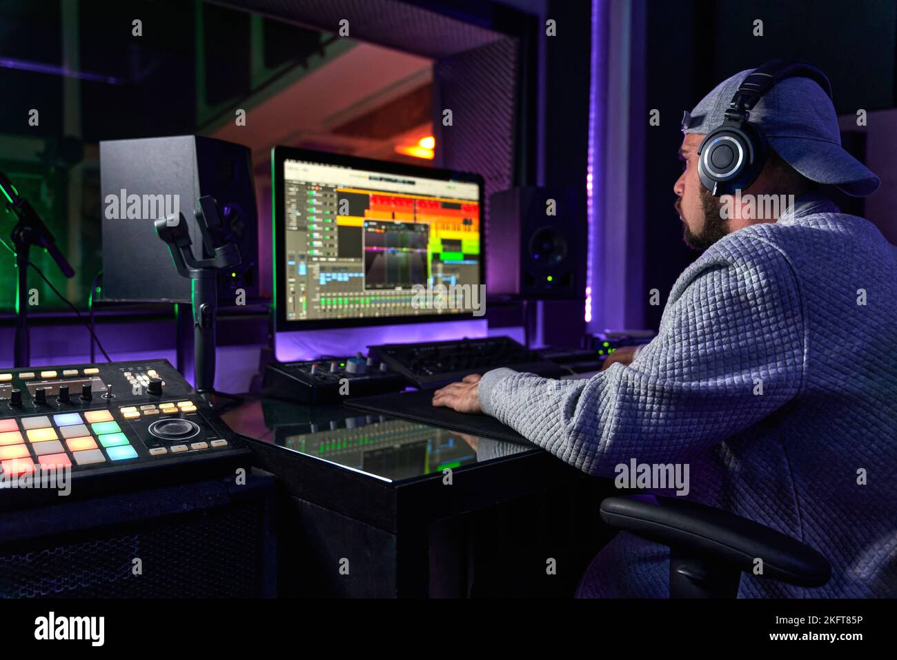 Back view of anonymous male audio engineer using computer while ...