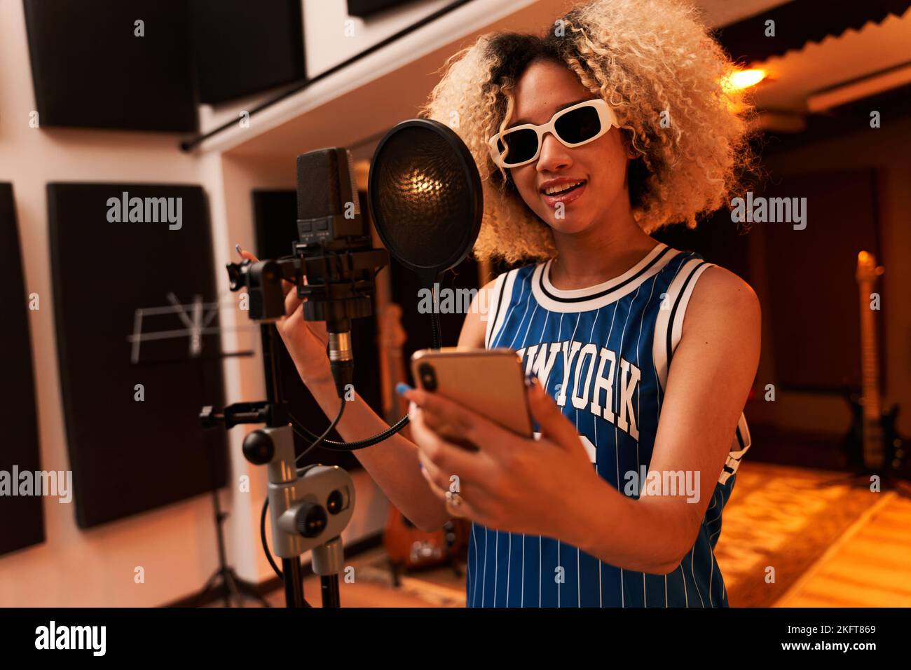 Positive young musician with Afro hairstyle in sunglasses standing in ...