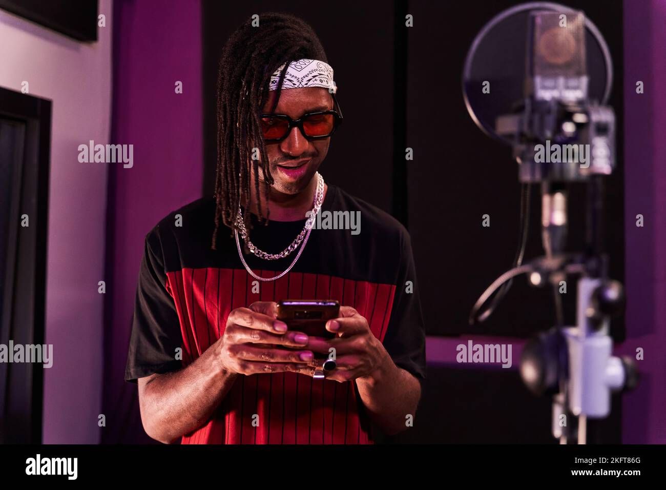 African American male musician with dreadlocks wearing bandana using ...